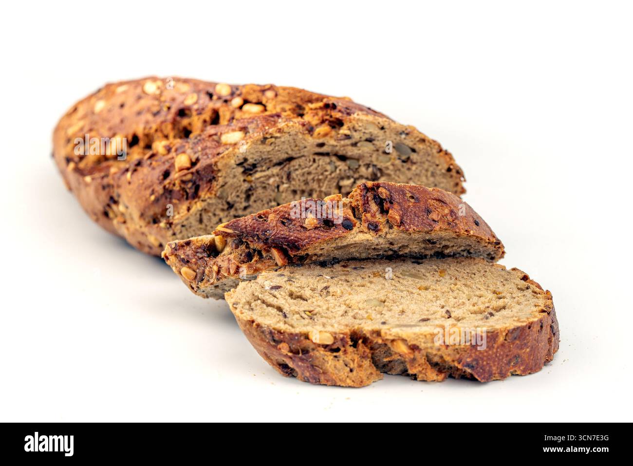 A slice of bread with nuts on it. The bread is cut in half Stock Photo ...