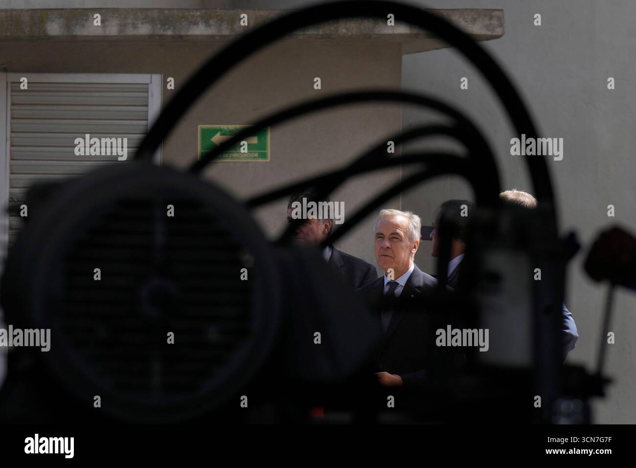 Prime Minister Mark Carney watches a vehicle unload wheat as he tours the Canadian Pacific and ...