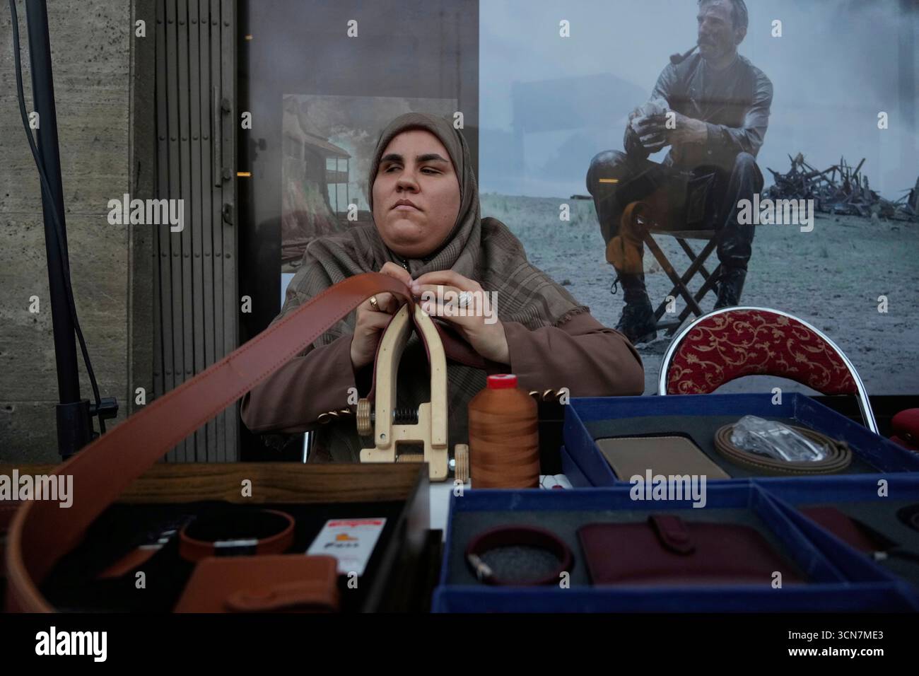 Blind Ghazal Zahedi crafts a belt in a street market where vendors sell ...
