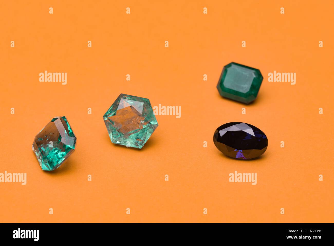 Four different colored gems are displayed on a yellow background. The ...