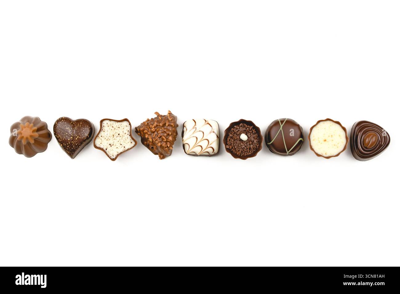 A row of chocolate truffles with different shapes and sizes. The ...