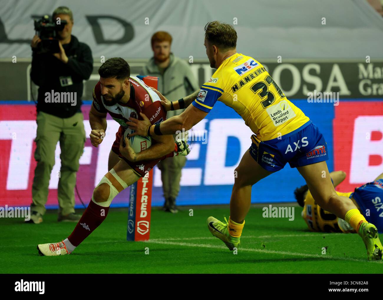 Wigan Warriors Abbas Miski (left) bursts through to score the opening ...