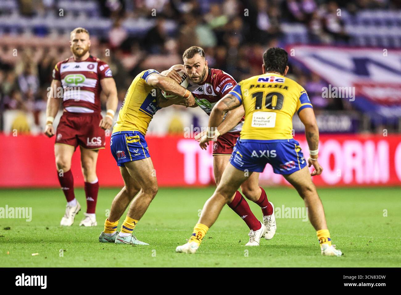 Kaide Ellis of Wigan Warriors is tackled during the Betfred Super ...