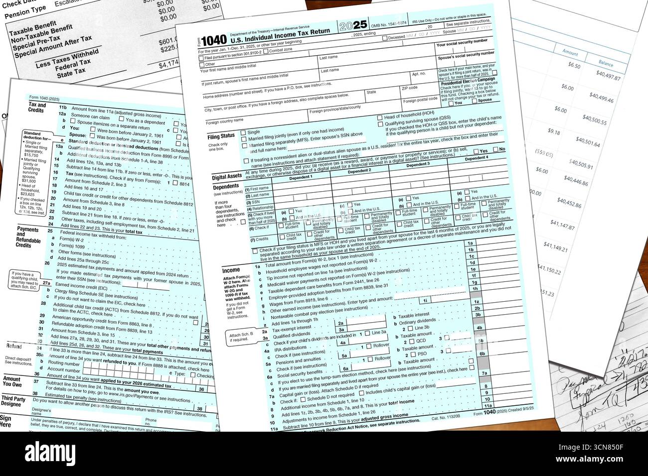 A 2025 tax year 1040 form and some notes and forms lay on a desktop ...
