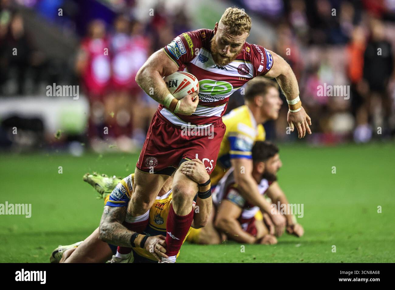 Luke Thompson of Wigan Warriors is tackled during the Betfred Super ...