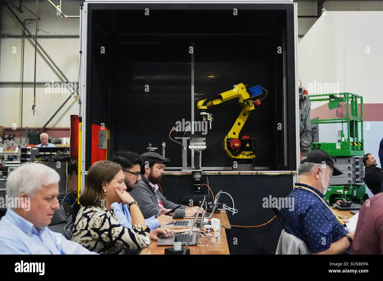 People work in front of a workstation for the Hatch Stamping Company ...
