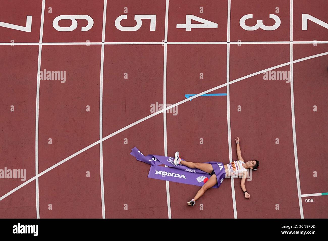 Spain's Maria Perez lays on the track after winning the women's 20 ...