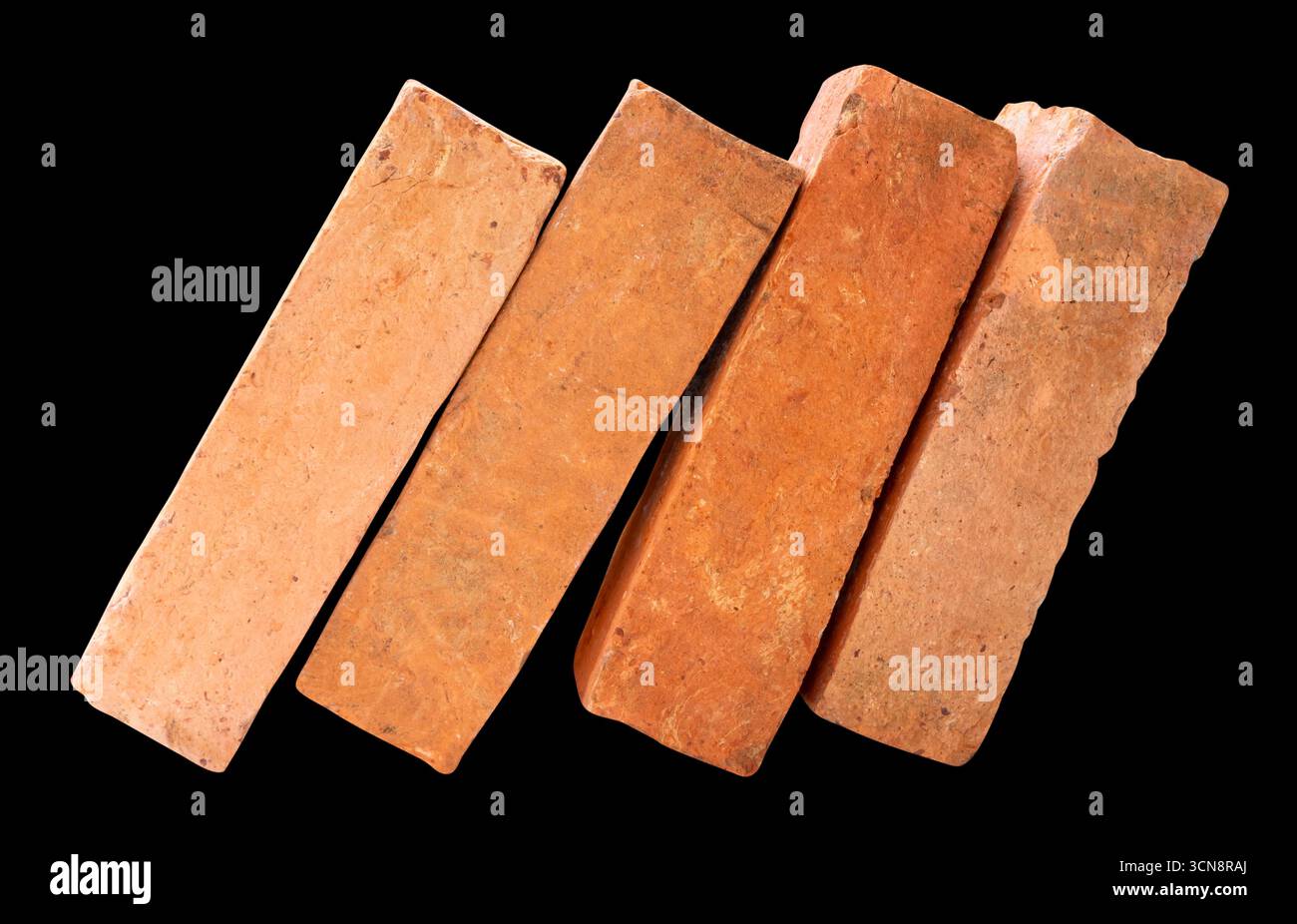 Side view of four cracked old red or orange bricks in stack is isolated ...
