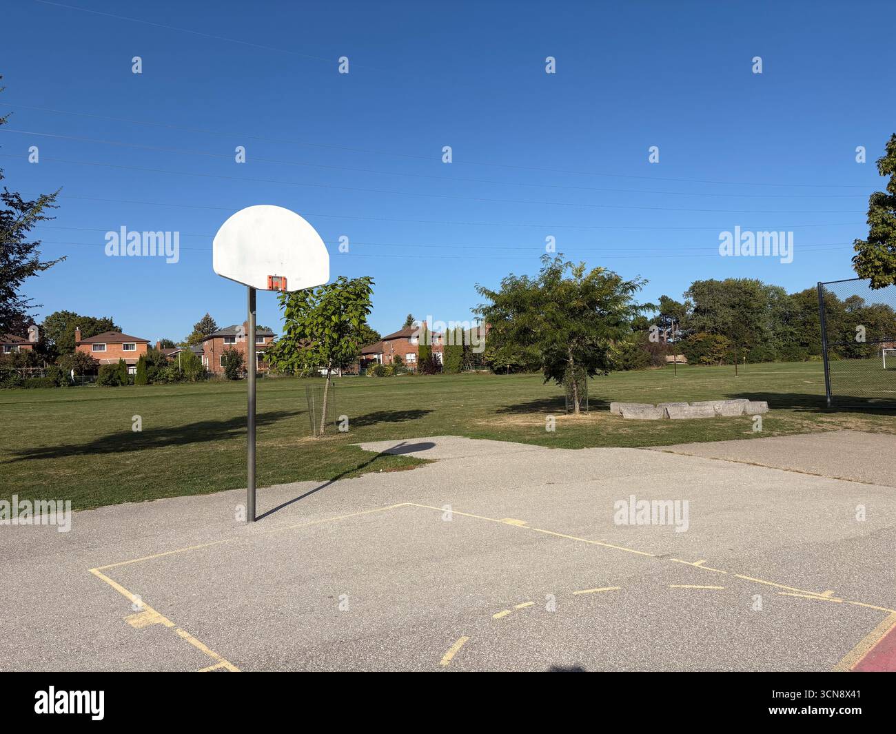 Outdoor basketball hoop. An old, white backboard and red rim stand ...