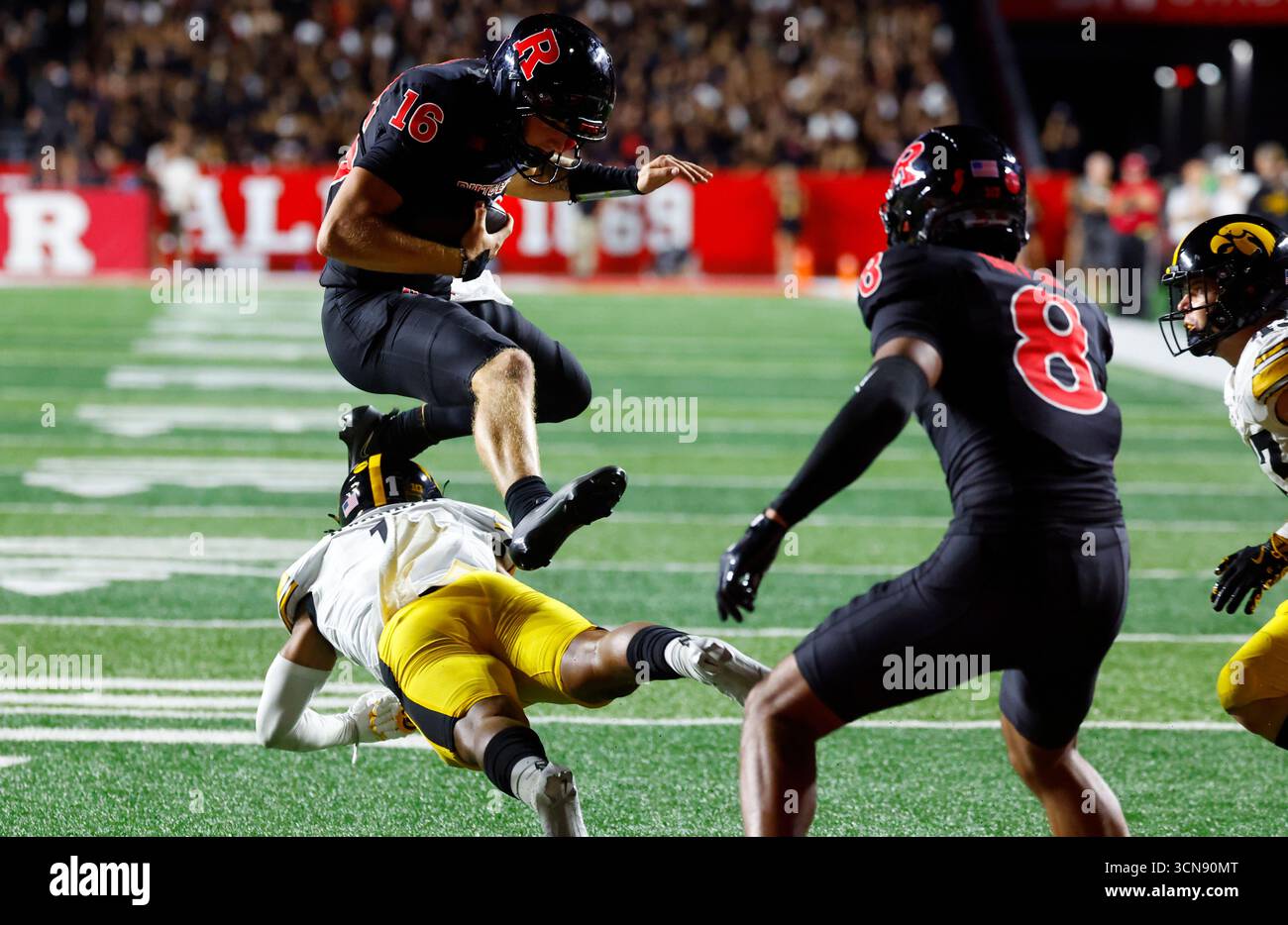 Rutgers quarterback Athan Kaliakmanis (16) hurdles Iowa defensive back ...