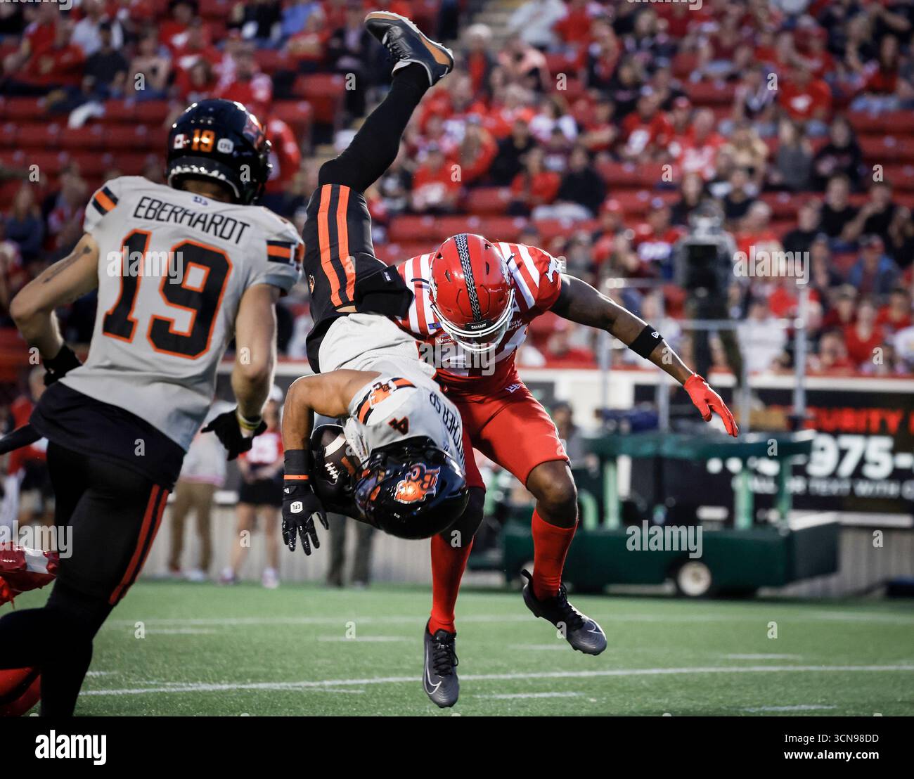 B.C. Lions' Keon Hatcher, left, is upended by Calgary Stampeders ...