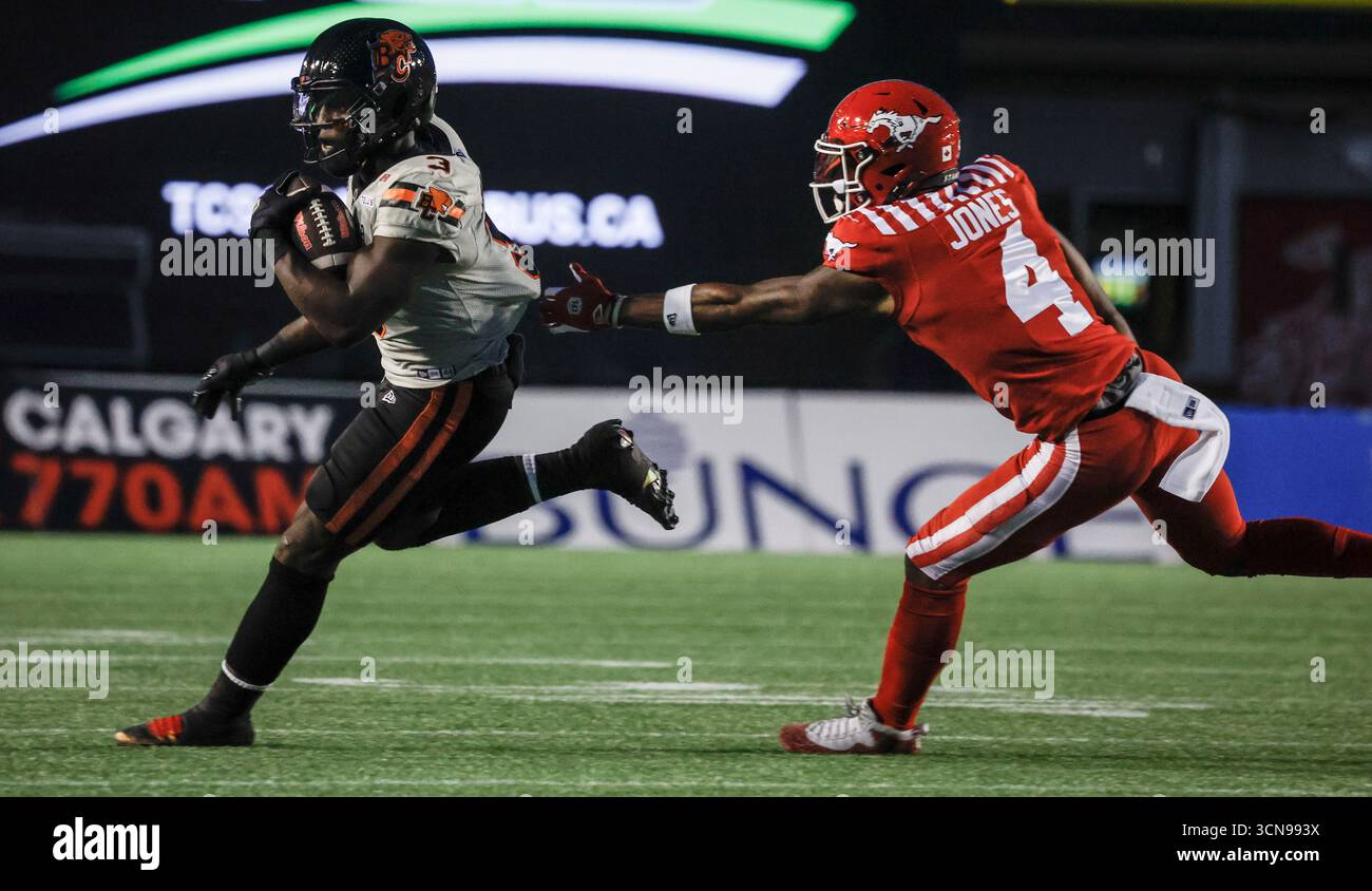 B.C. Lions' Micah Awe, left, runs an interception as Calgary Stampeders ...