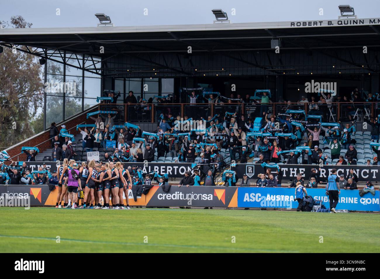 Players of Port Adelaide huddle up during the warm up song during the ...