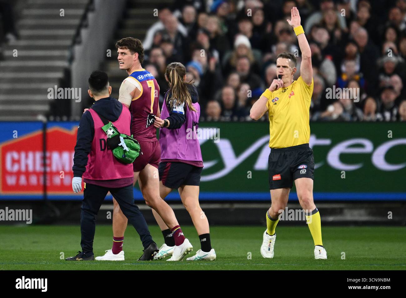 Jarrod Berry of the Lions is assisted by a trainer during the AFL ...