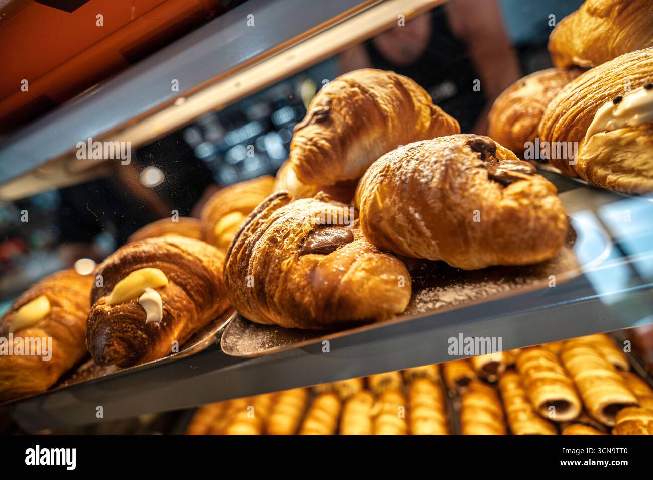 Golden croissants and italian pastries neatly arranged in a bakery ...