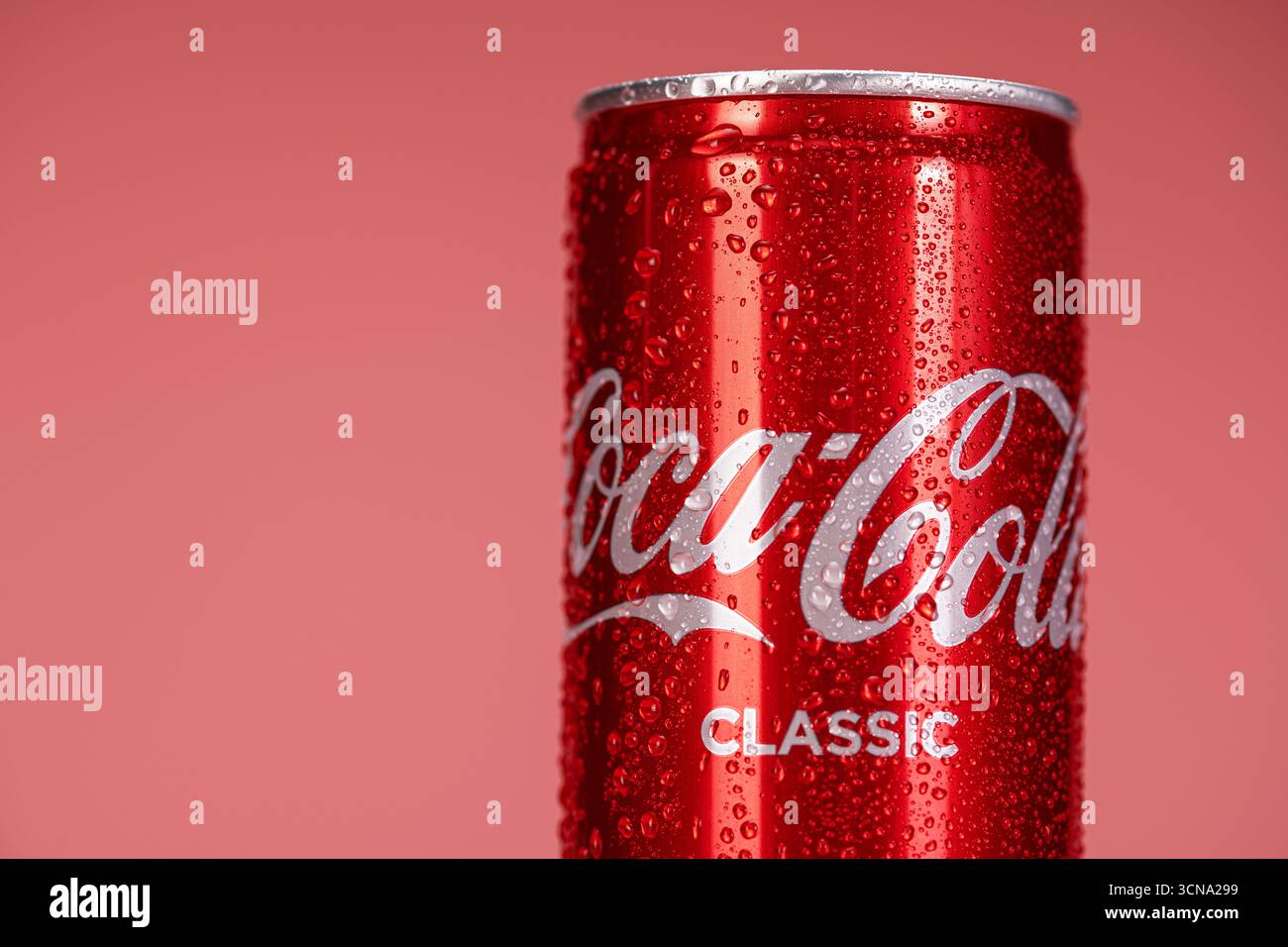 A can of Coca-Cola Classic is sitting on a red background. The can is ...