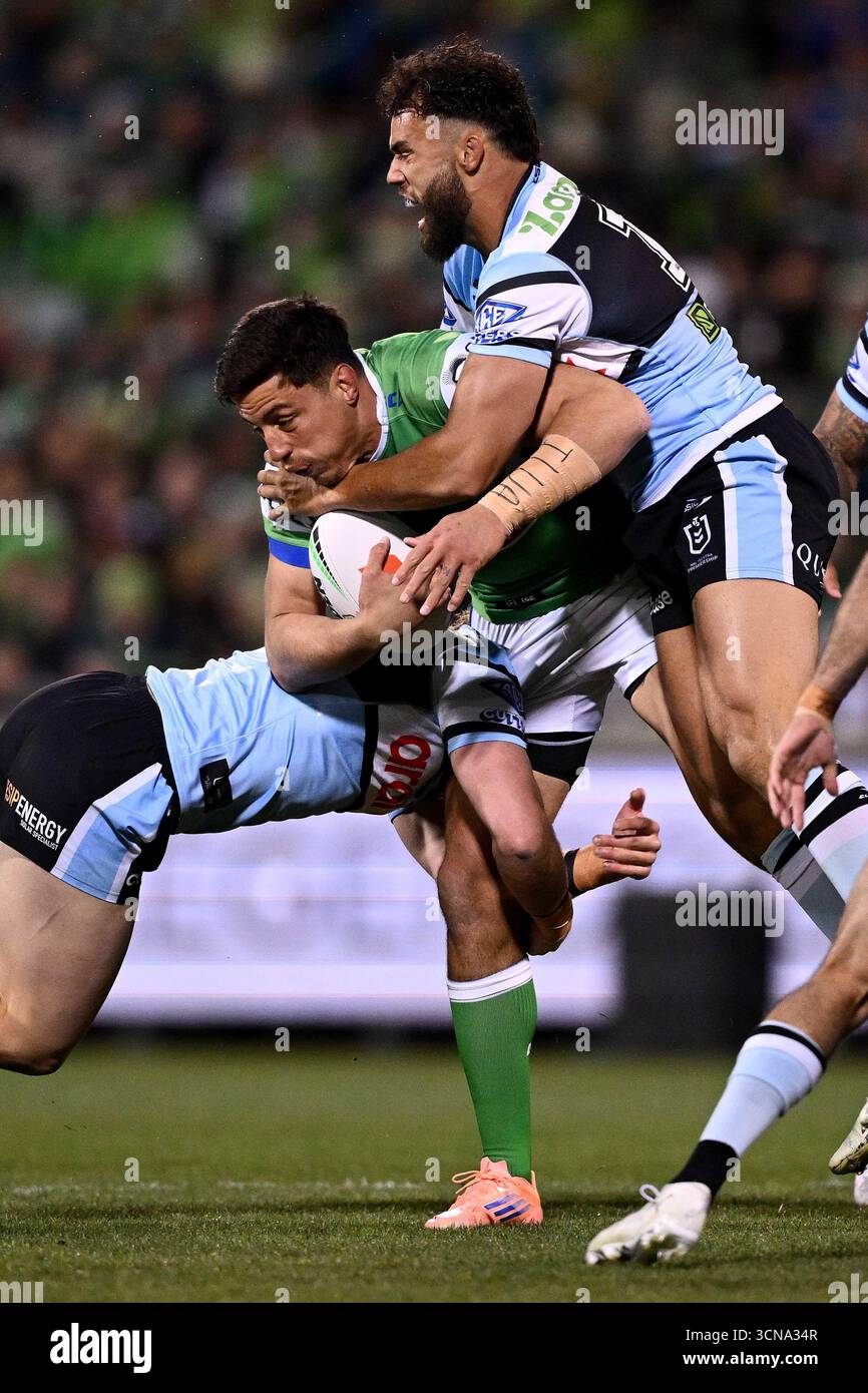 Joseph Tapine of the Raiders is tackled by Jesse Colquhoun (left) and ...