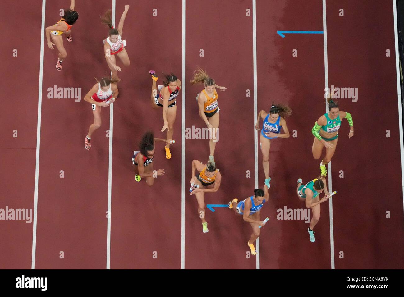 Athletes pass the baton during a women's 4 X 400 meters relay heat at ...