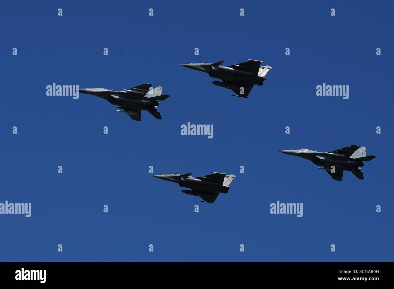 Serbian army MiG-29 jets, left and right, and French Air Force Rafale ...