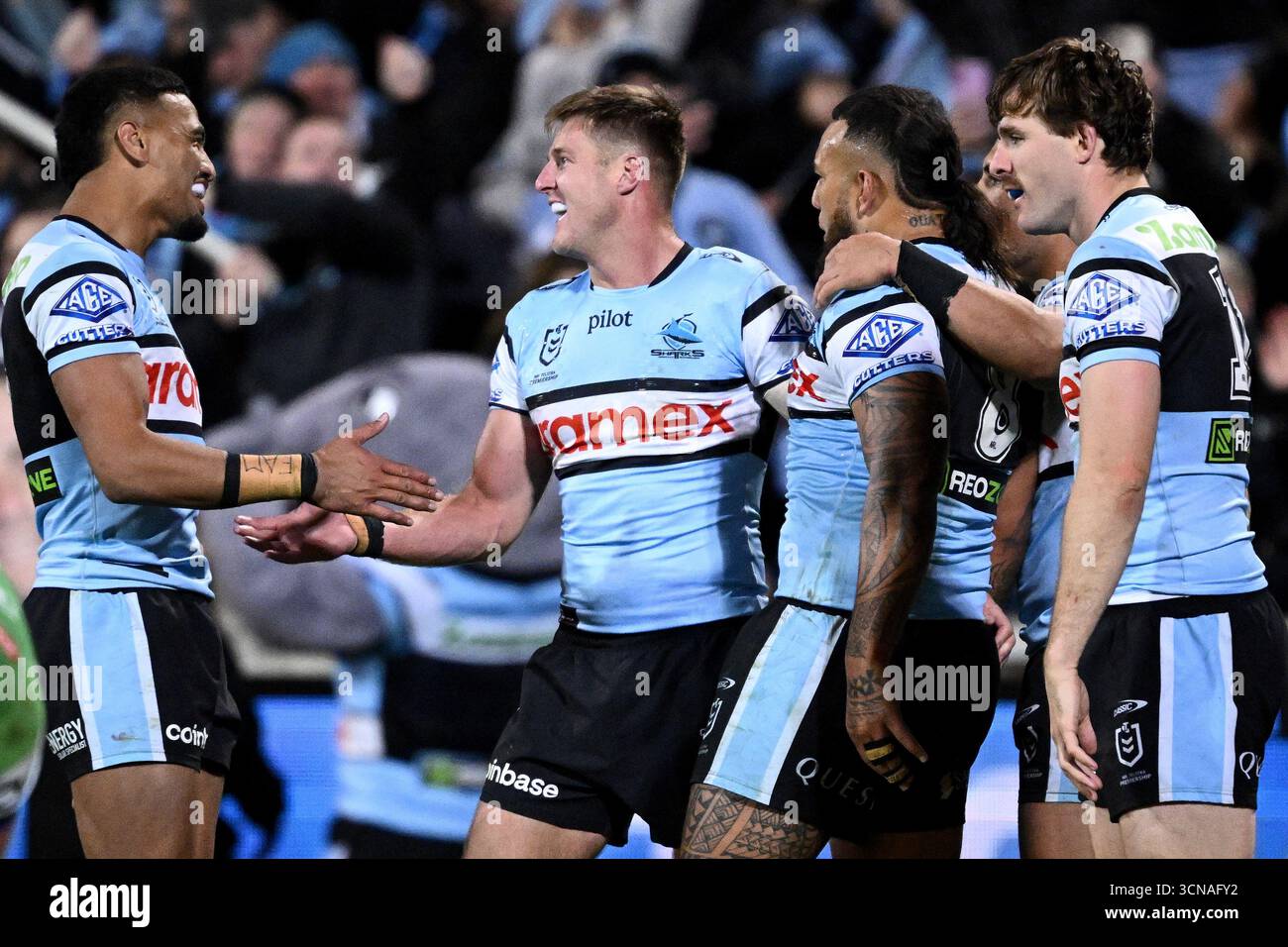 Teig Wilton of the Sharks (centre) celebrates with teammates after ...