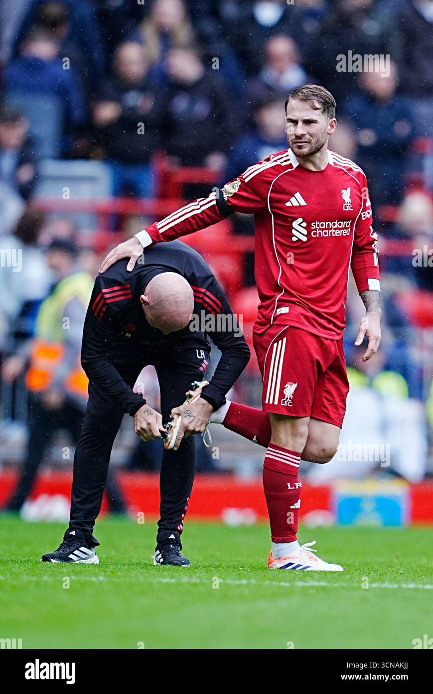 Liverpool's Alexis Mac Allister (right) has his boots mended by ...