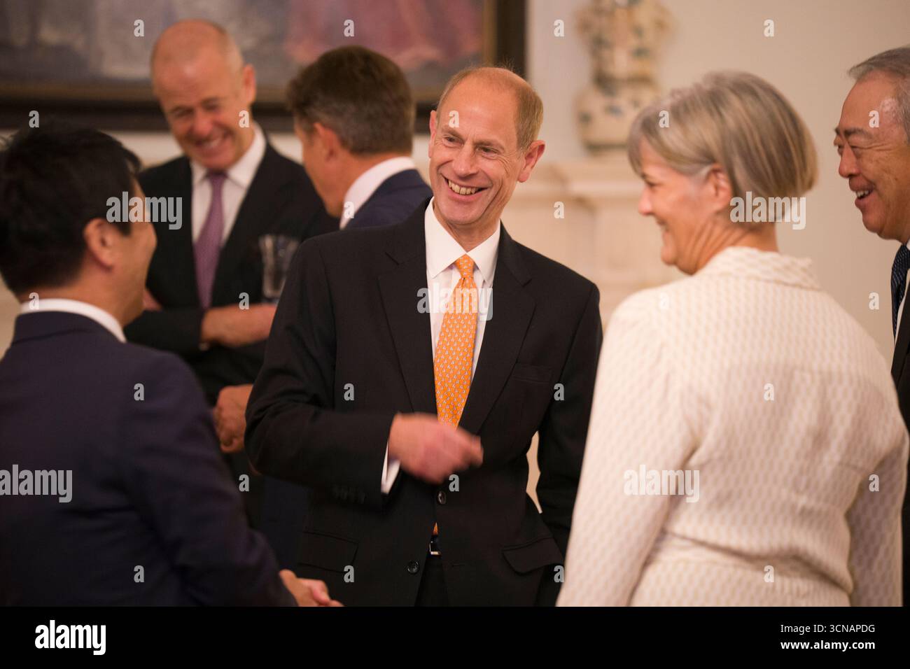 The Duke of Edinburgh (centre) peaks with guests during a reception ...