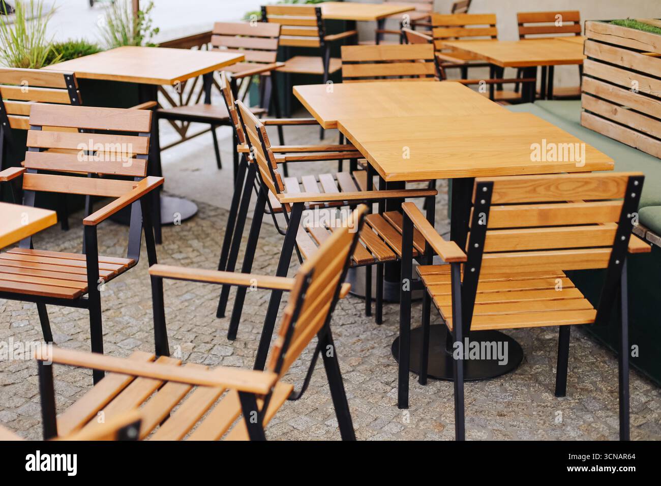 Outdoor cafe terrace. Wooden tables with chairs. Empty seating area in ...