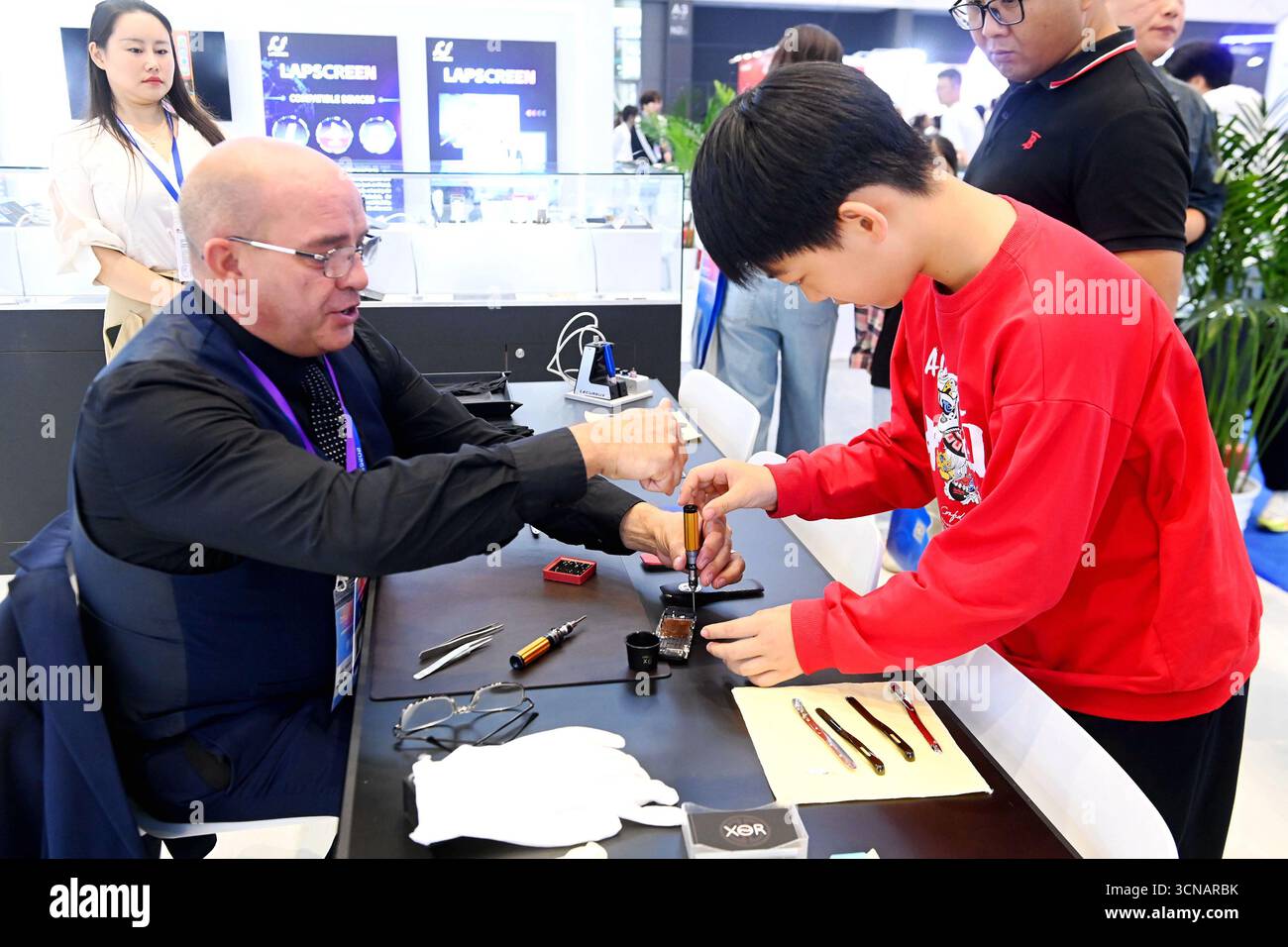 QINGDAO, CHINA - SEPTEMBER 20, 2025 - A child exchanged ideas with ...