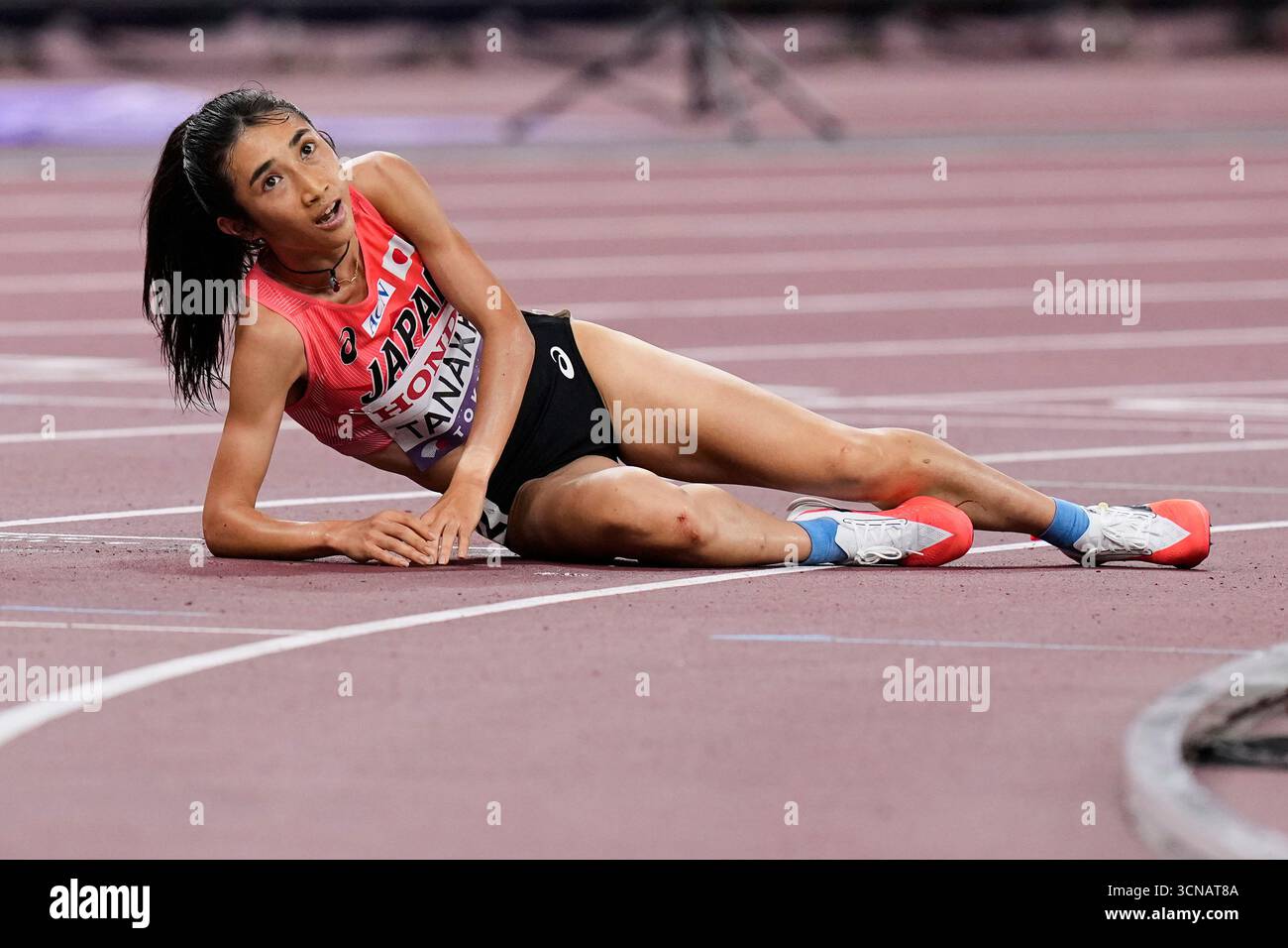 Japan's Nozomi Tanaka lies on the track after the women's 5,000 meters ...