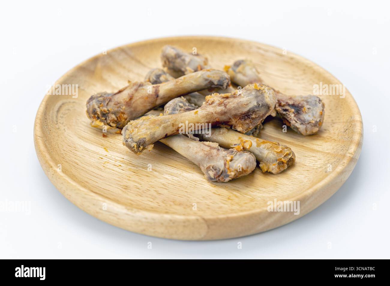 A chicken bone wooden plate leftover food waste white background cooked ...