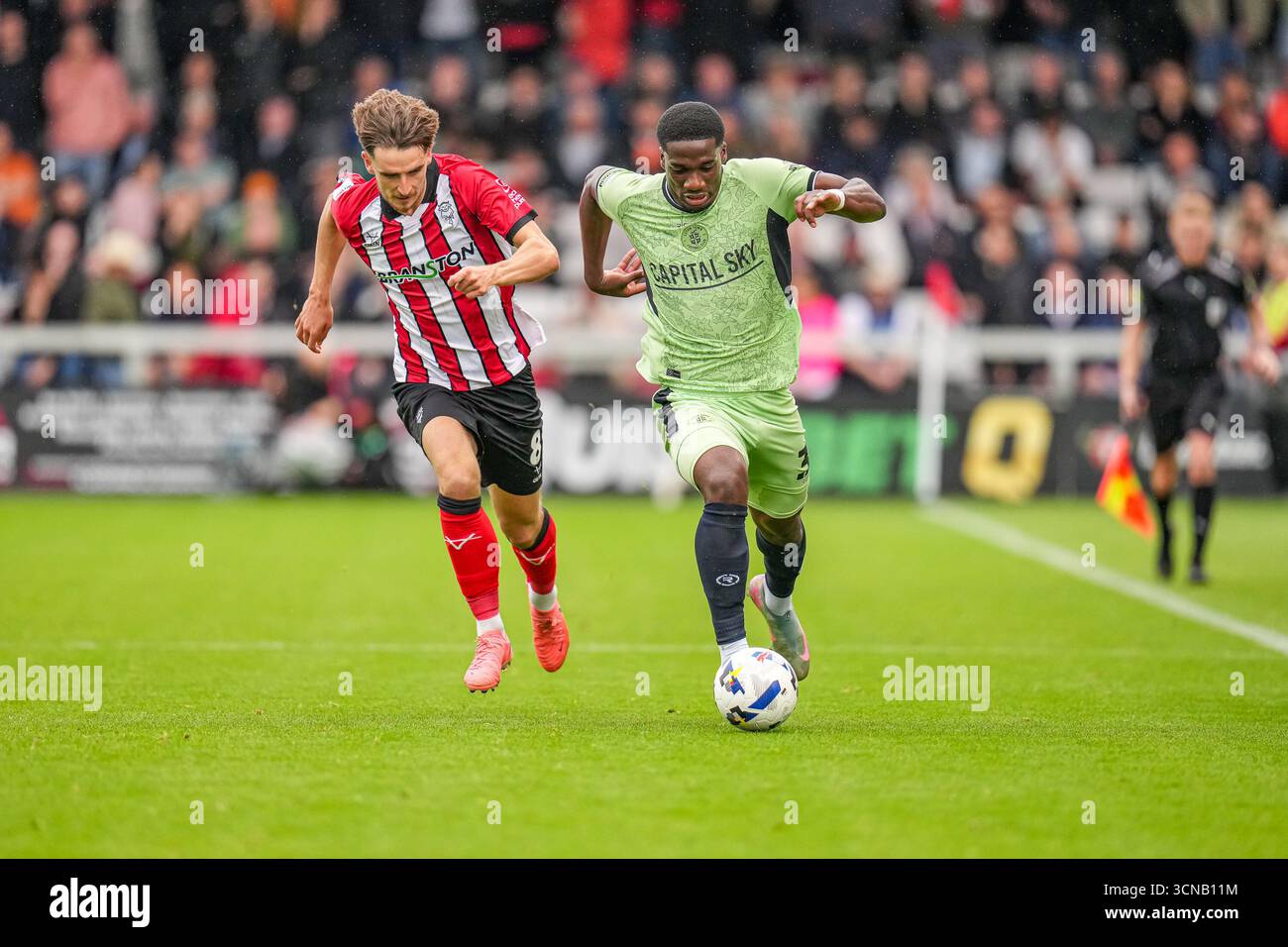 Tom Bayliss (8) of Lincoln City and Joseph Gbode (31) of Luton Town ...