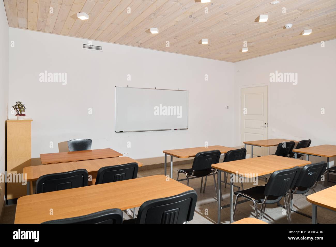 The modern classroom setup features a spacious layout with desks and a ...