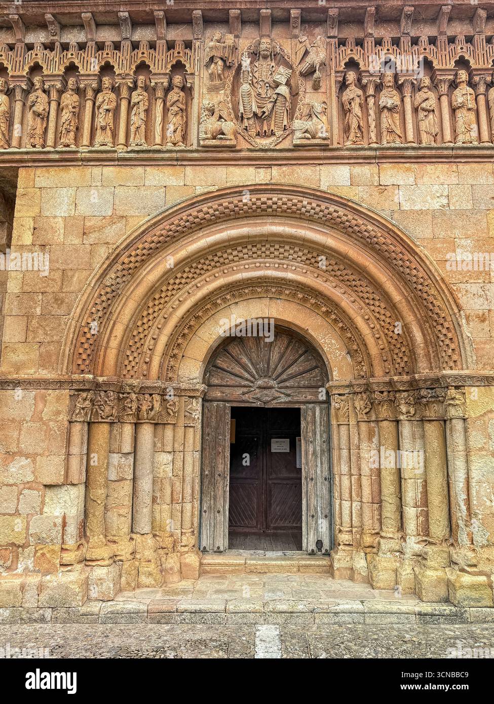 Close-up of Romanesque church portal with decorated archivolts and ...