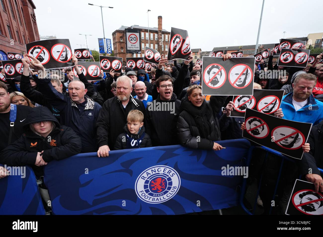 Campaigners hold Rangers banners, and signs opposing Rangers head coach ...