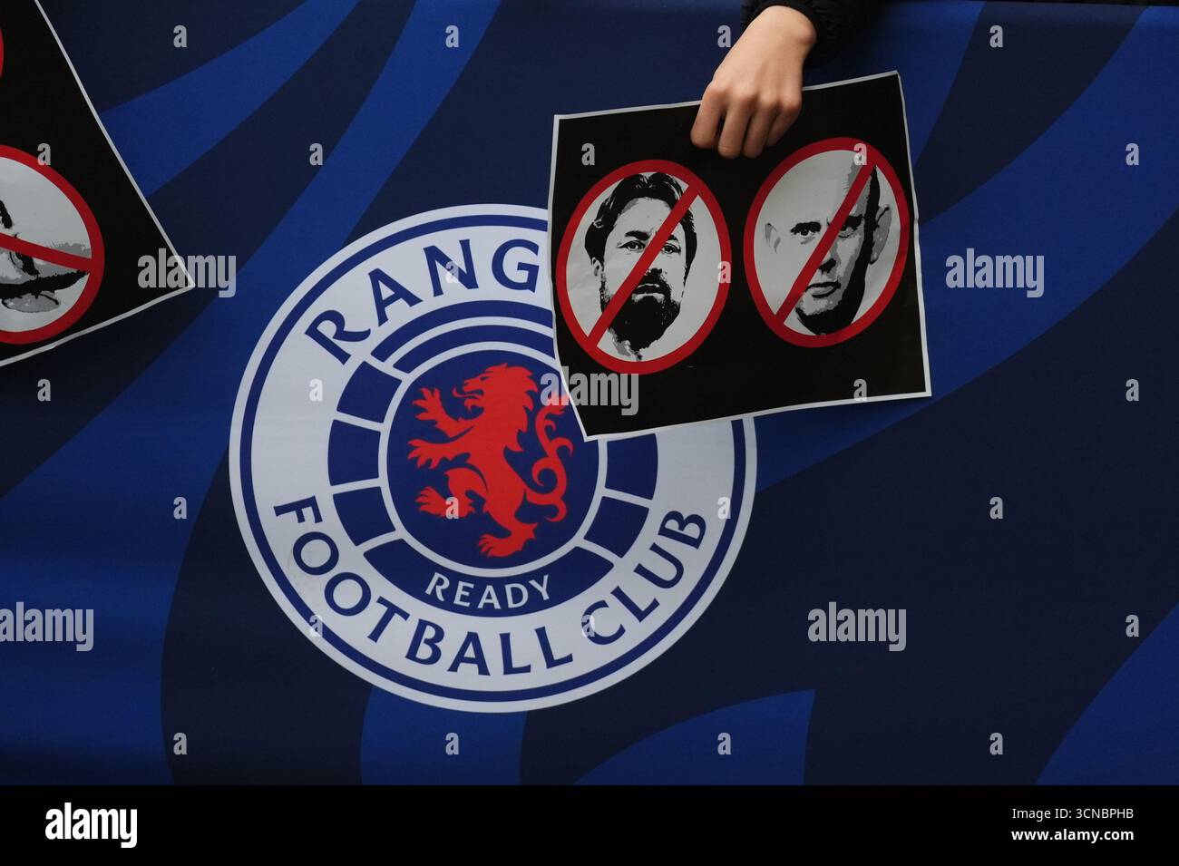 Campaigners hold Rangers banners, and signs opposing Rangers head coach ...
