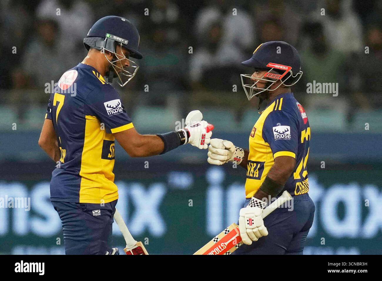 Sri Lanka's Dasun Shanaka, left, fist-bumps with batting partner ...