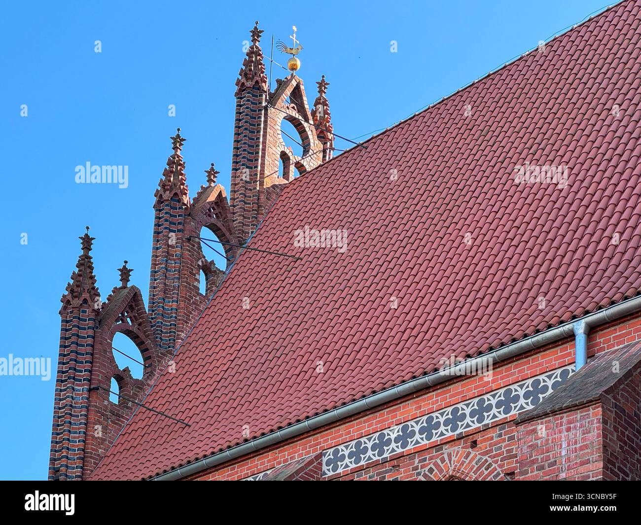 Detailed view of spires and roofline on gothic brick catholic church ...