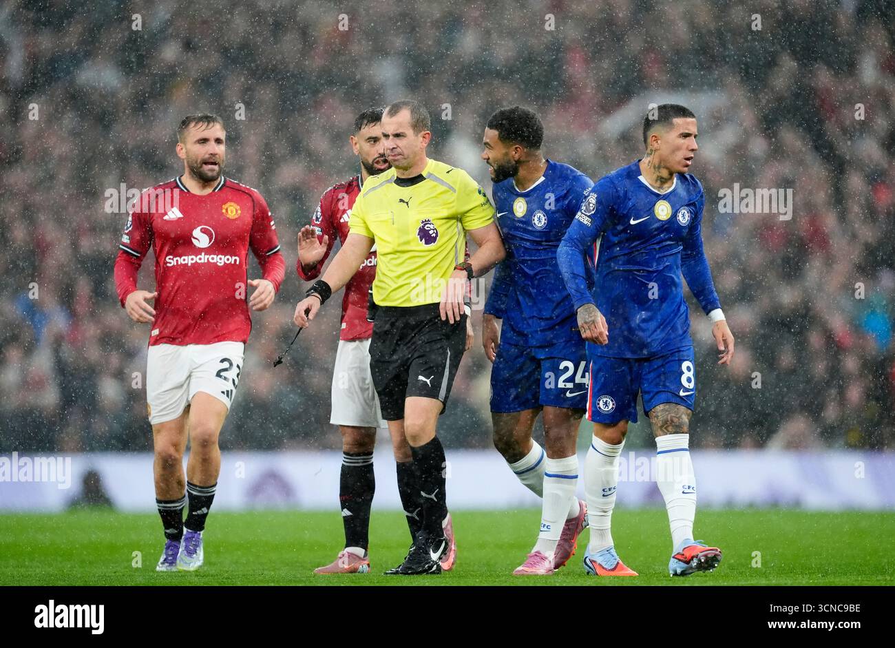 Referee Peter Bankes (centre) receives pressure from players from both ...