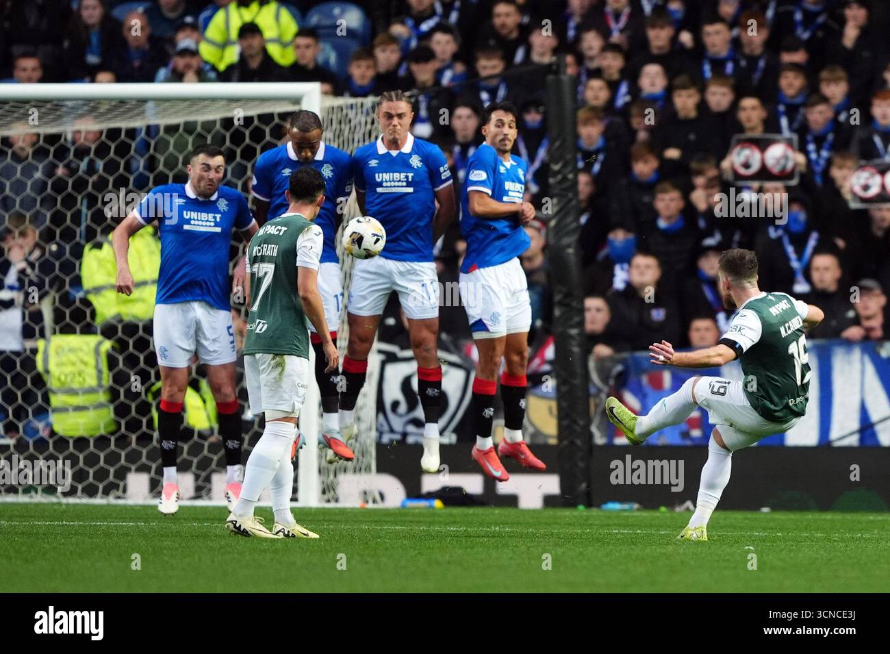 Hibernian's Jack Iredale (right) hits a free kick towards goal during ...