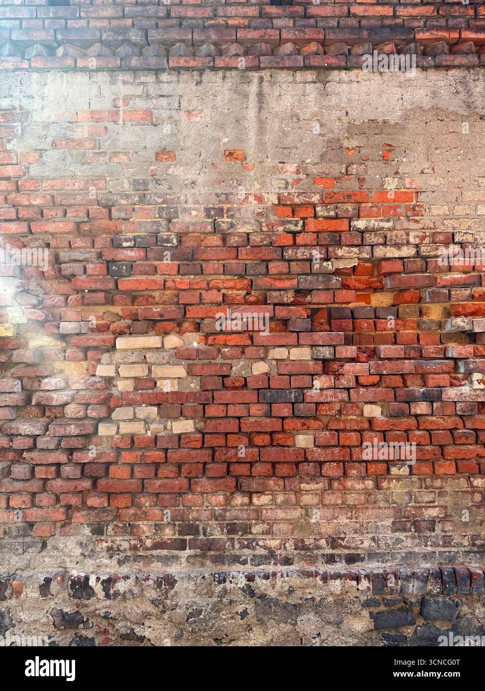 Red brick wall with visible sunlight and lens flare adding contrast ...