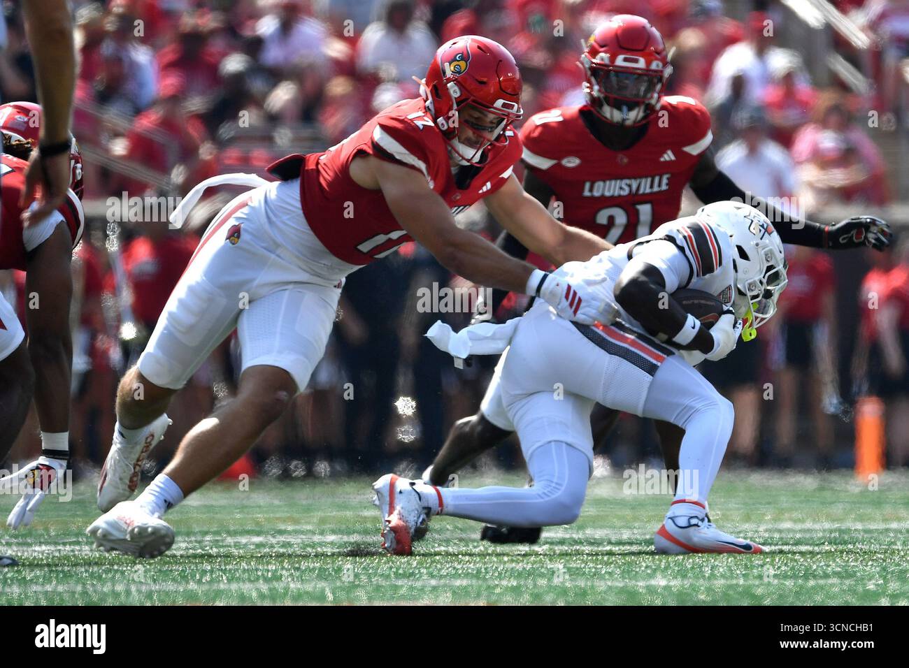 Louisville linebacker Kalib Perry (12) grabs Bowling Green safety Kal ...