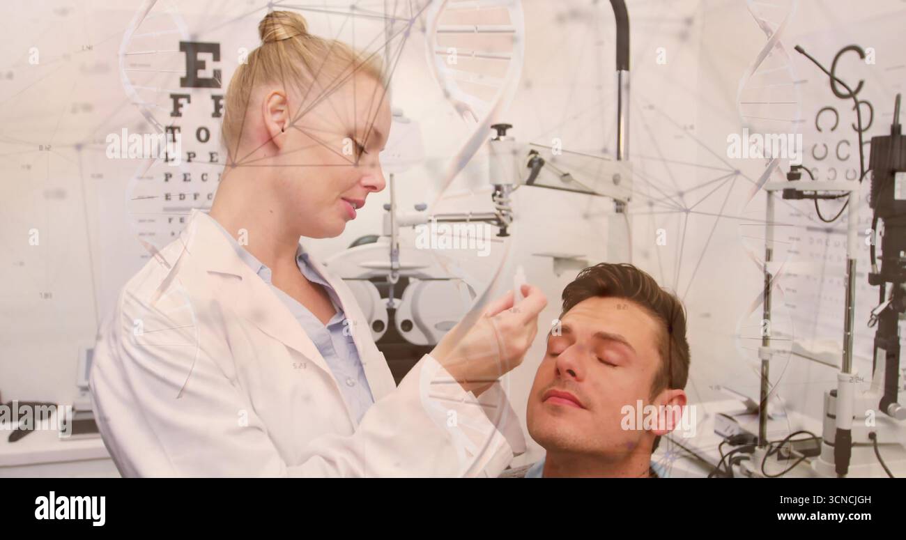 Female optometrist applying eye drops and examining male patient in ...