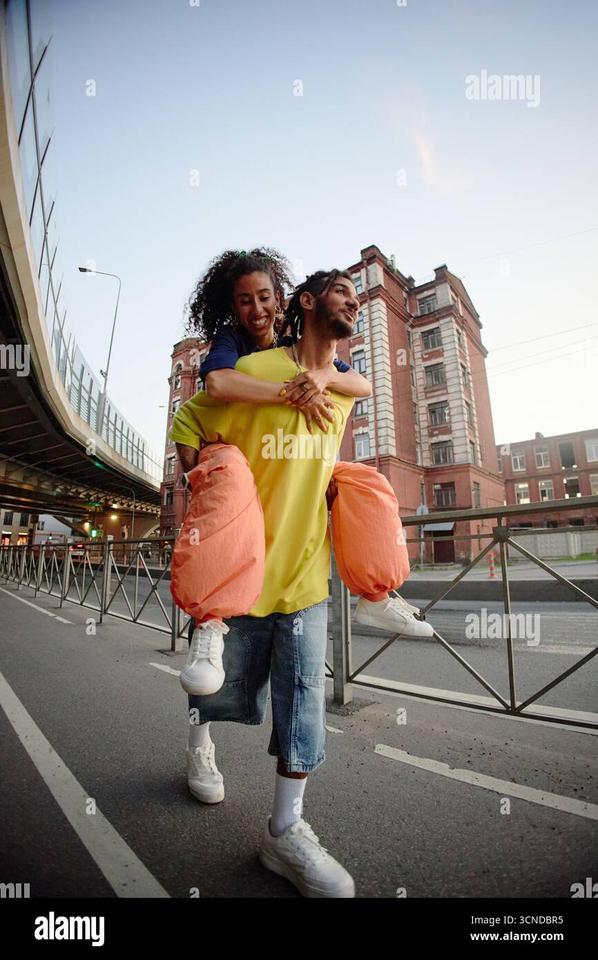 Multiethnic Gen Z Couple Having Fun Outdoors during Piggyback Ride in ...