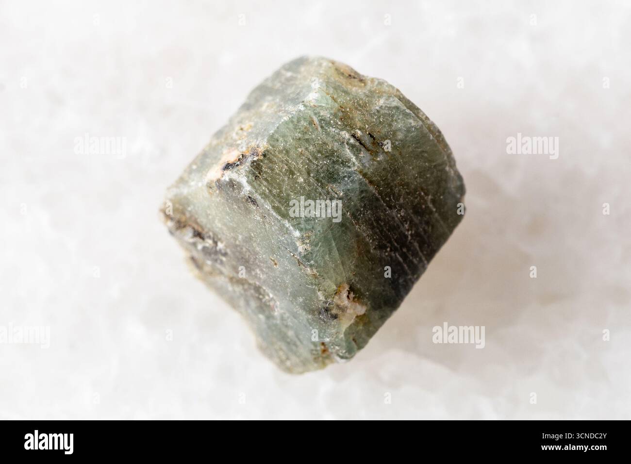 sample of raw green sapphire corundum mineral on white marble ...