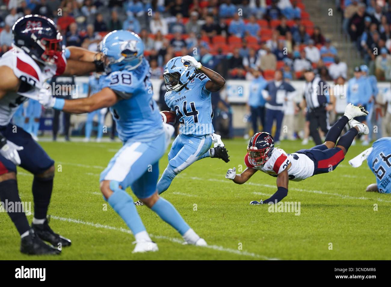 running back Deonta McMahon #24 of Toronto Argonauts avoids a tackle in ...