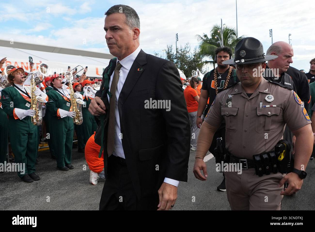 Miami head coach Mario Cristobal, left, arrives for an NCAA college ...