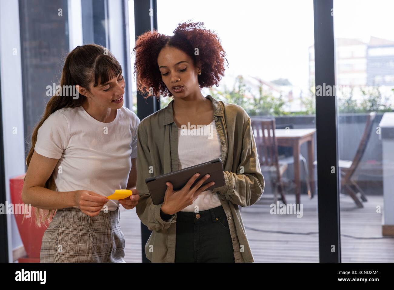Diverse female coworkers scrolling tablet hi-res stock photography and ...