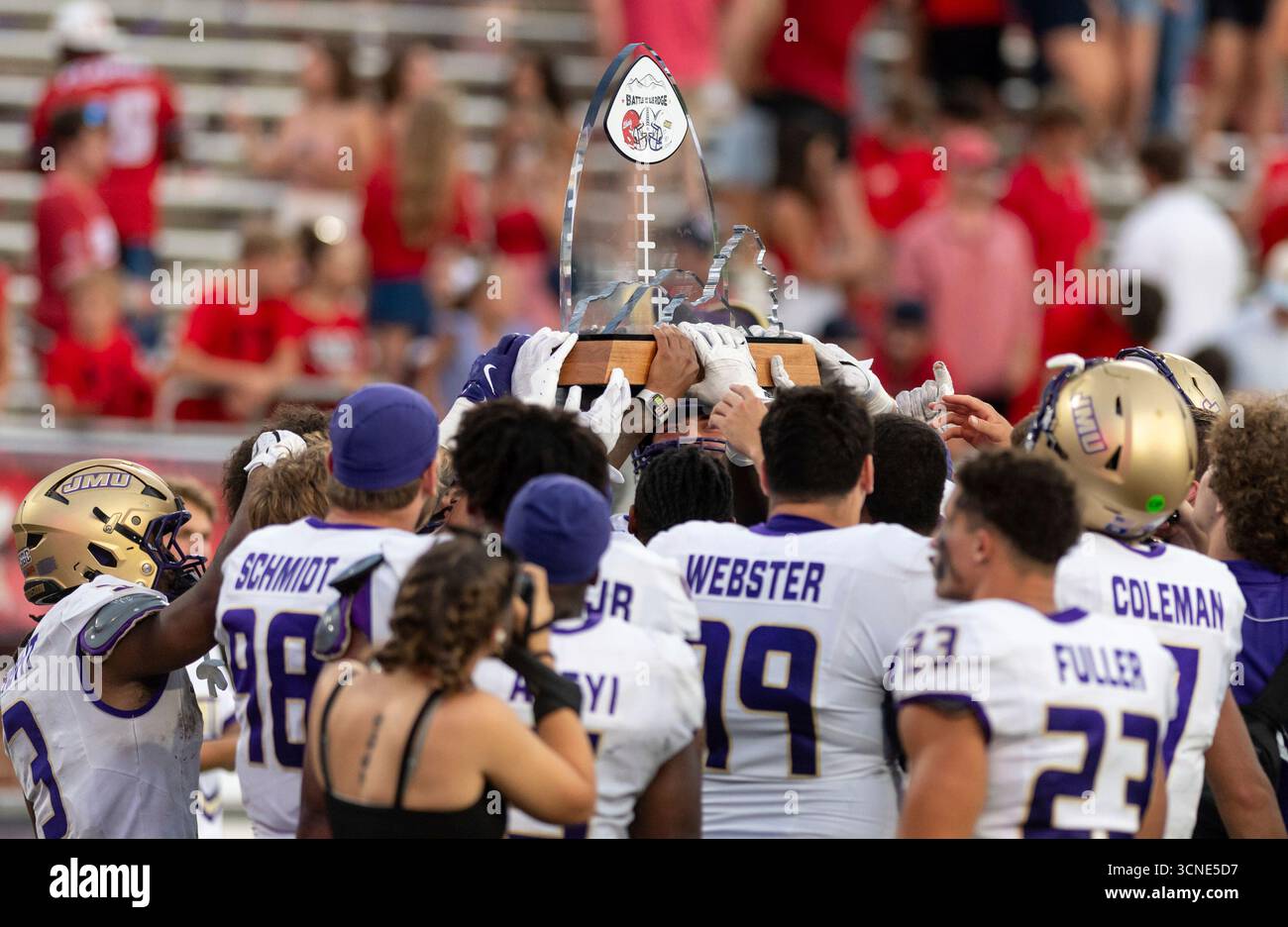 James Madison players hoist the Battle of the Blue Ridge trophy after ...