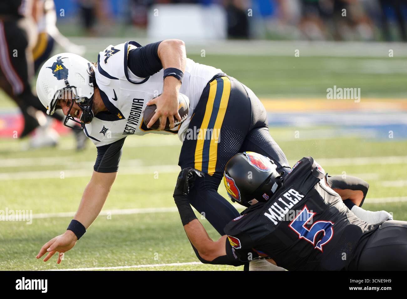 West Virginia quarterback Nicco Marchiol, left, is sacked by Kansas ...