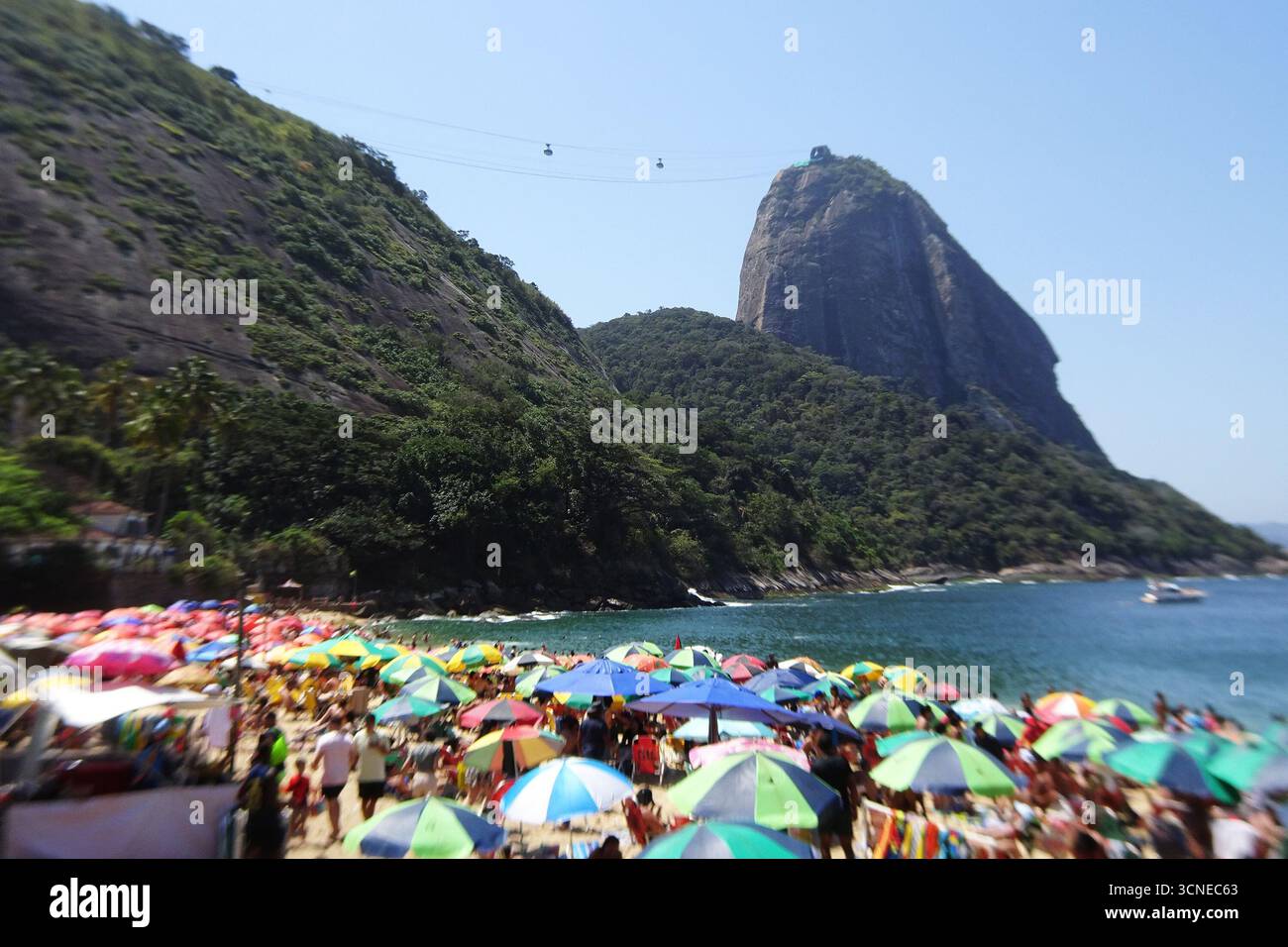 Beachgoers enjoy the sunny and warm weather at Praia Vermelha beach in ...